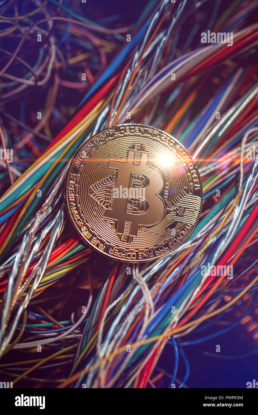 Bitcoin crypto currency coin on the top of colorful bundle of cables ...