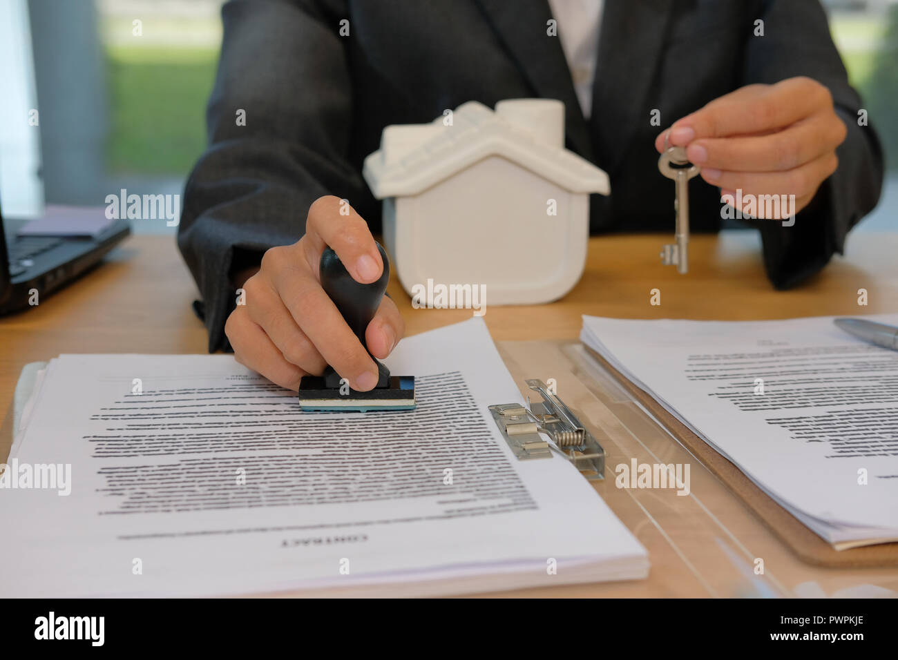 real estate agent with house key using stamper for stamping approved on ...