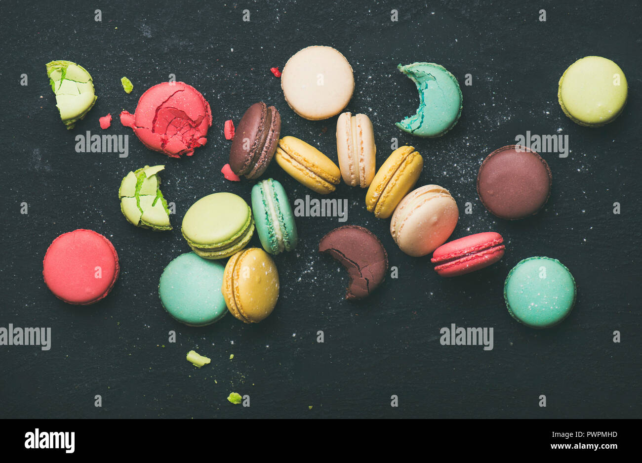 Flat-lay of sweet colorful French macaroon cookies variety over black ...