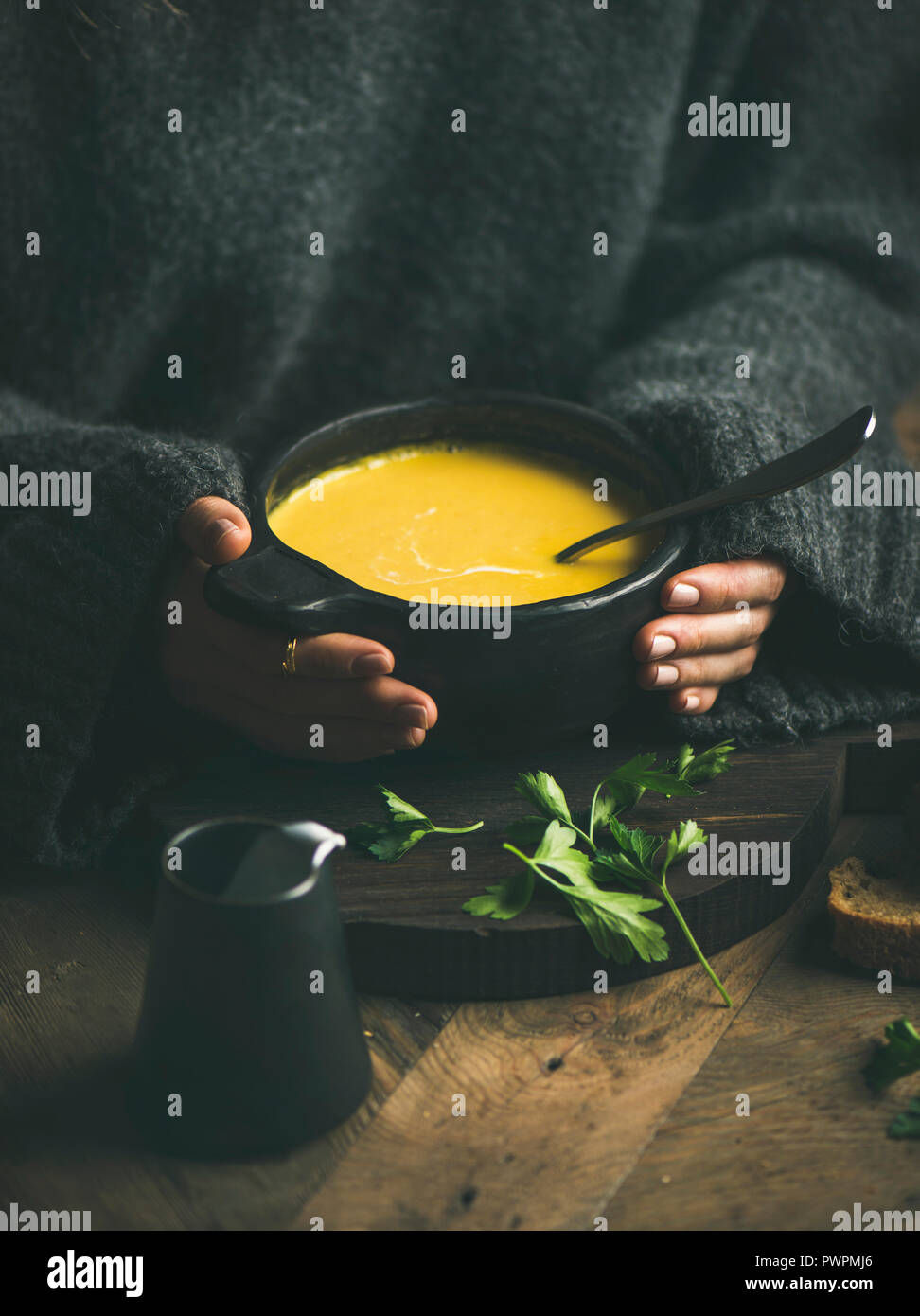 Woman in dark grey woolen winter sweater eating sweet corn and shrimp ...