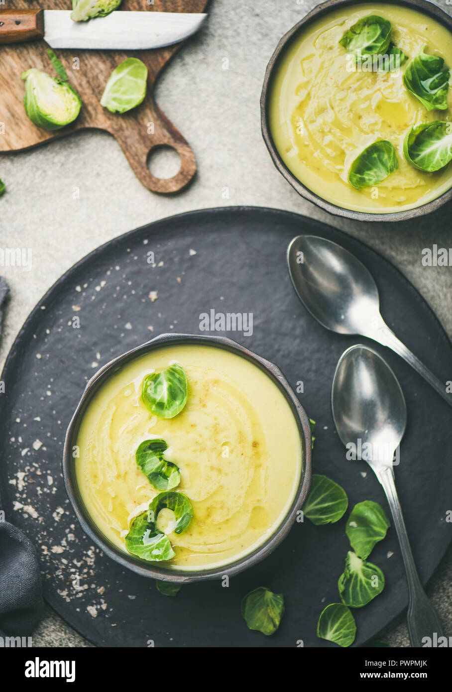 Seasonal brussels sprouts vegetable cream soup in black bowl and fresh ...