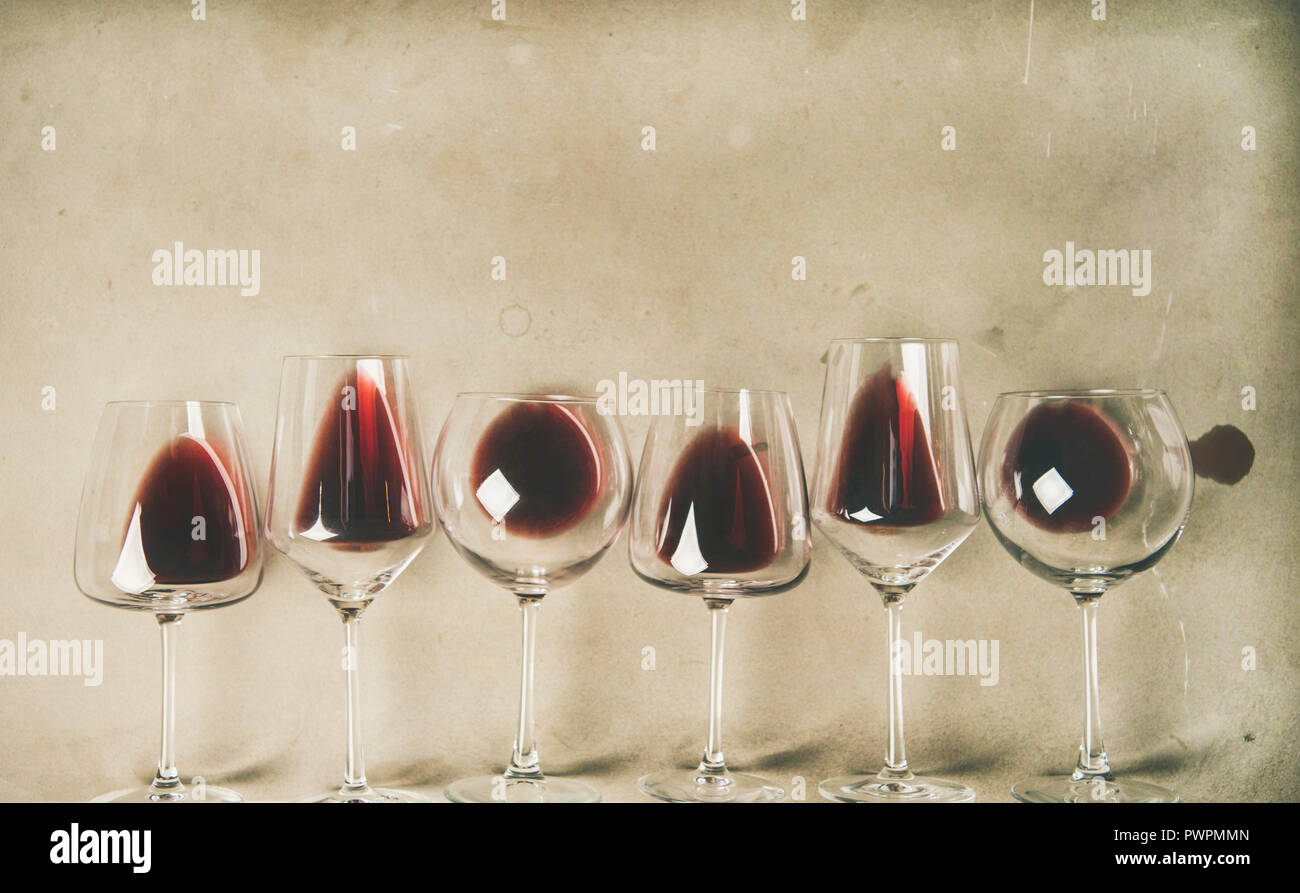 Flat-lay of red wine in different glasses over grey concrete background ...