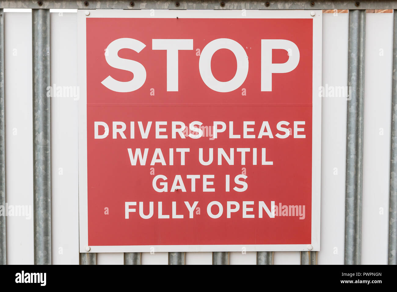 STOP drivers please wait until gate is fully open sign Stock Photo - Alamy