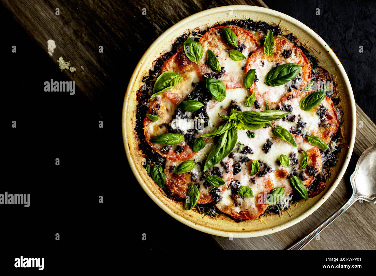 Caprese Black Rice Casserole served in a ceramic bowl. Photographed on ...