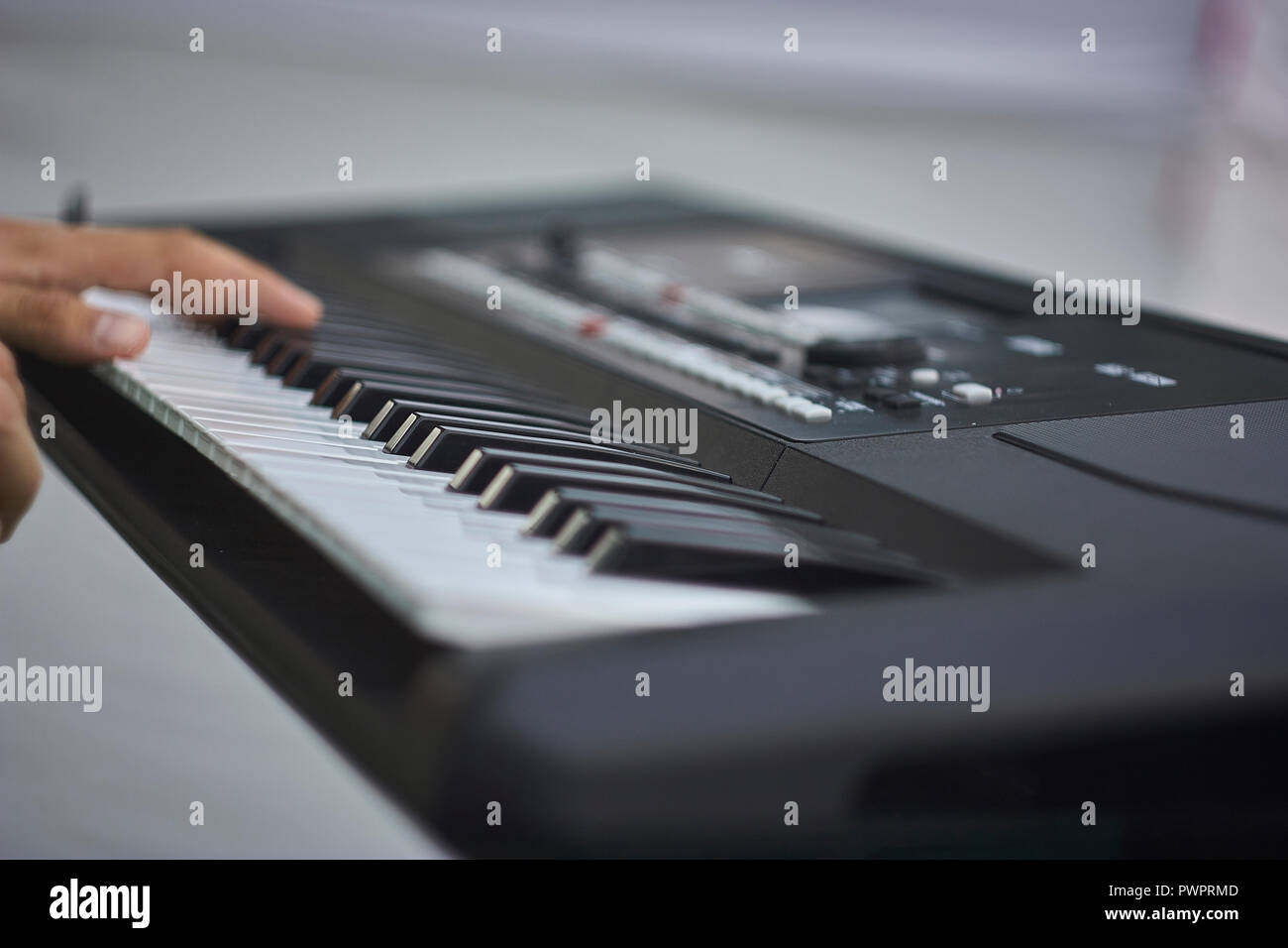 Hand of a musician pressing the keys of an electronic keyboard while ...