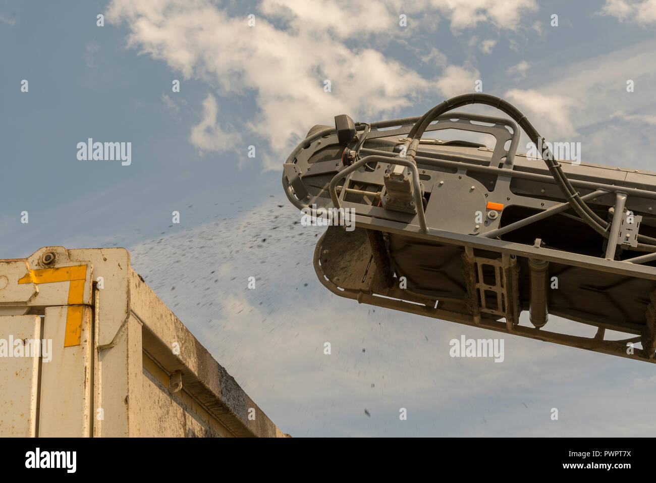 loading road debris in the car. A heavy tractor removes the old asphalt ...