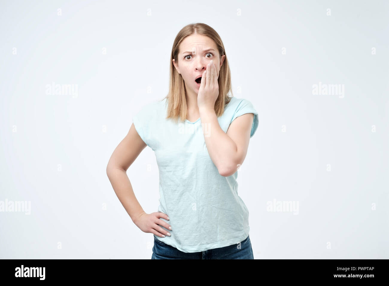 Stupefied stunned woman keeps mouth widely opened, looks in terror at ...