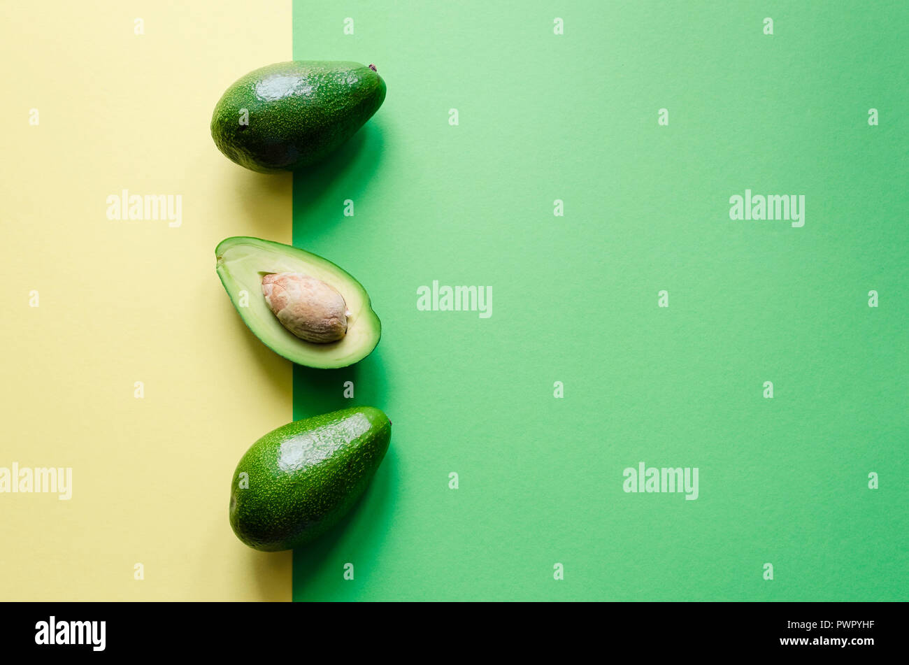 Organic avocado with seed and whole fruits on color yellow and green ...