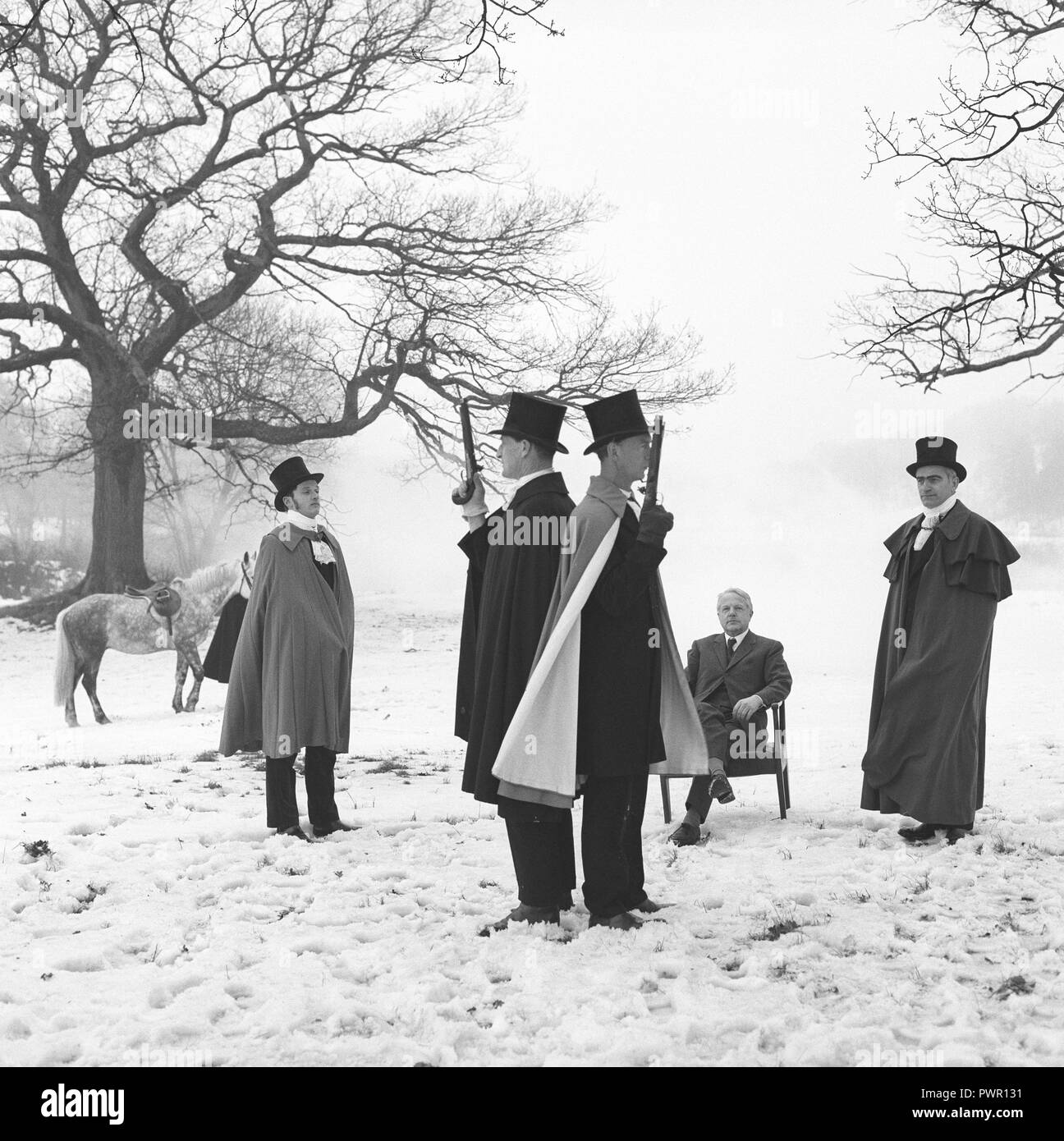 Duel of gentlemen. Two men are standing back to back holding pistols ...