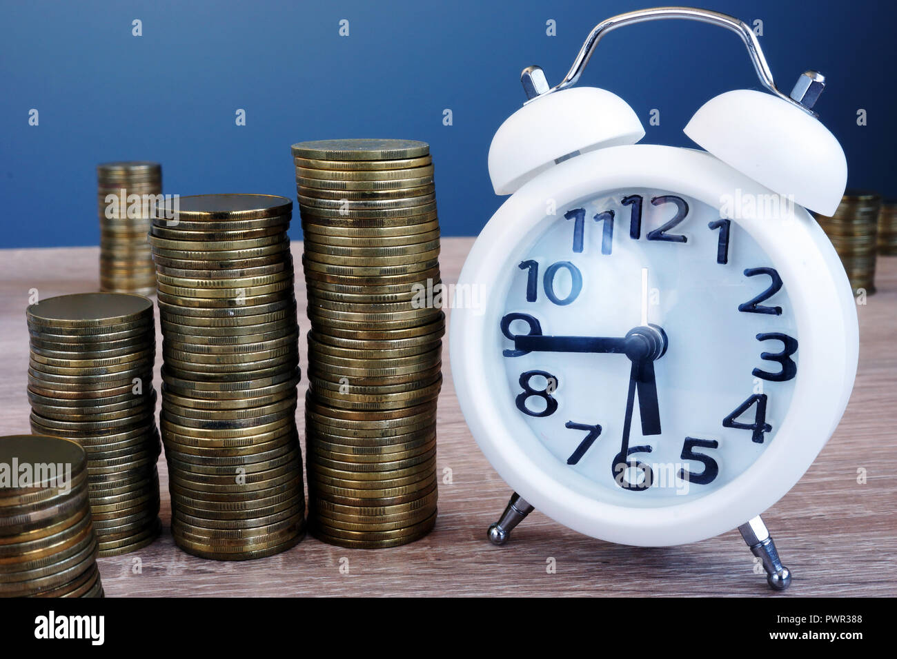 Clock and stacks of coins. Wealth growth Stock Photo - Alamy