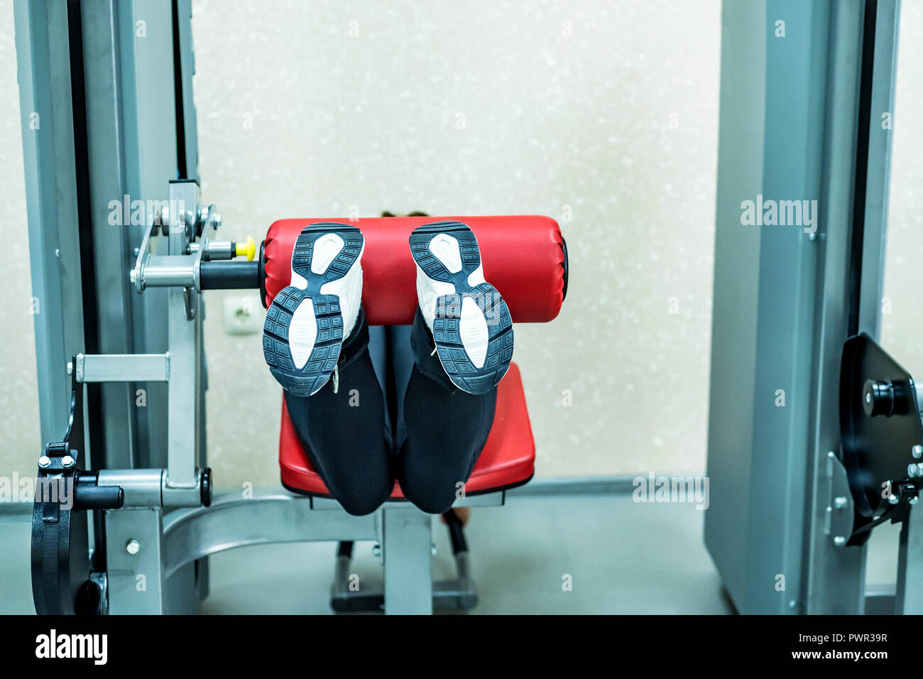 Young woman does leg exercises in gym lying Stock Photo - Alamy