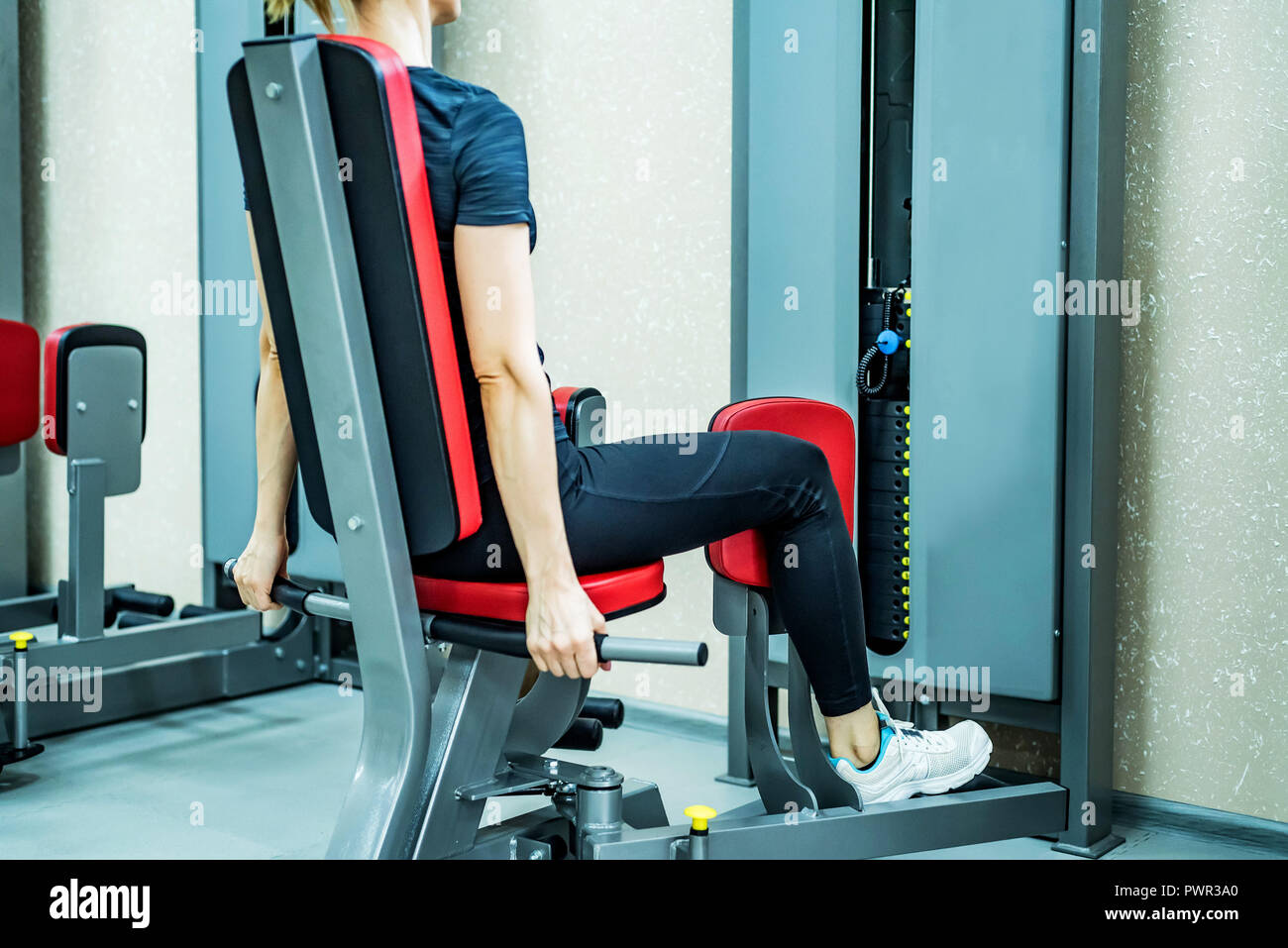 Side view young woman does leg exercises in gym Stock Photo - Alamy