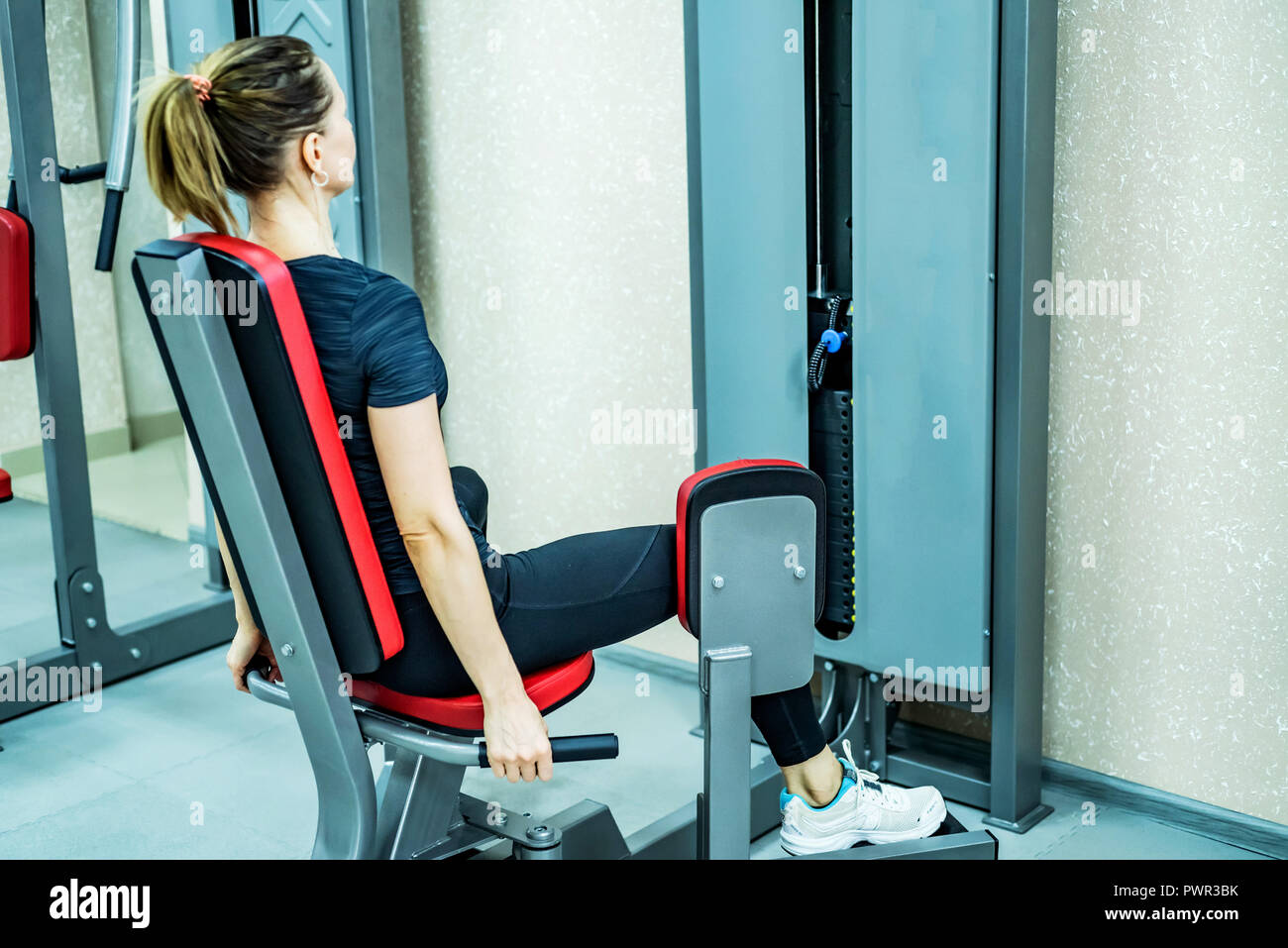 Side view young woman does leg exercises in gym Stock Photo - Alamy