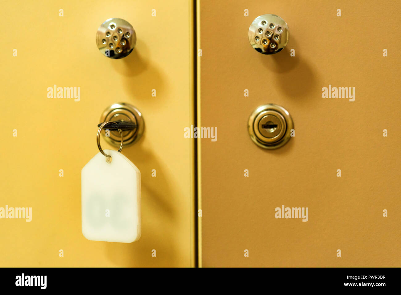 Wooden doors with key in sports gym locker room Stock Photo - Alamy