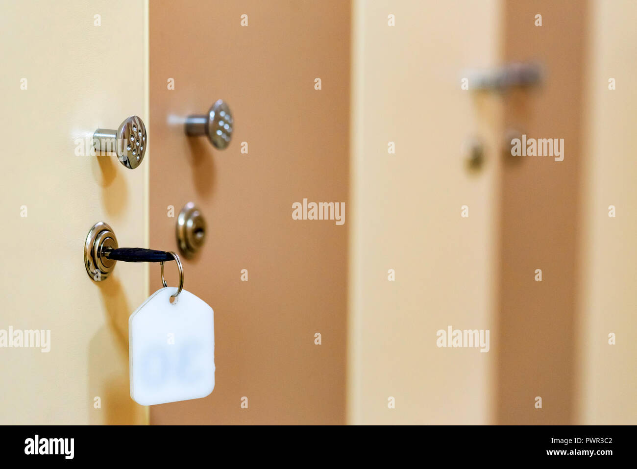 Wooden doors with key in sports gym locker room Stock Photo - Alamy