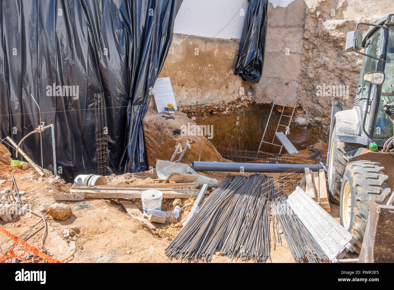Small building site with a deep trench for foundations with excavating ...