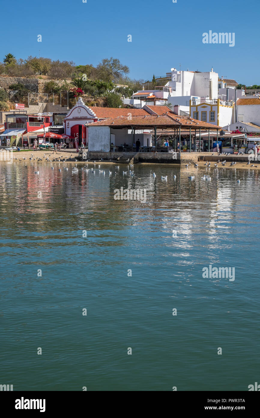 A fisherman filleting fish by the quayside in Alvor Stock Photo - Alamy