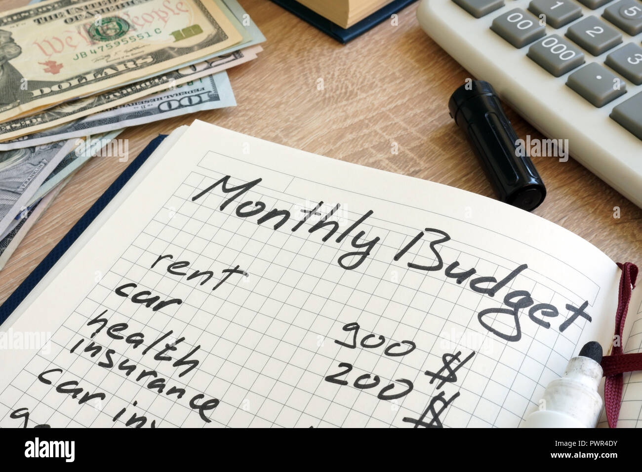 Note pad with monthly budget calculations and money Stock Photo - Alamy
