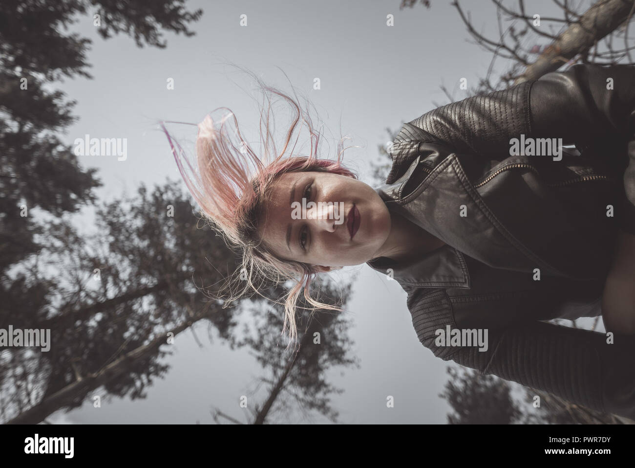 Young woman looking on the ground in woods Stock Photo - Alamy