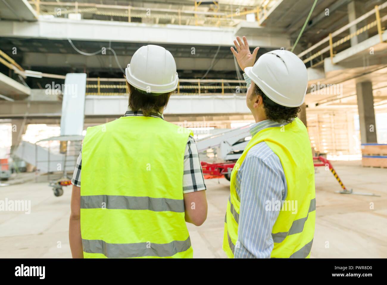 Male construction worker and engineer at the construction site ...