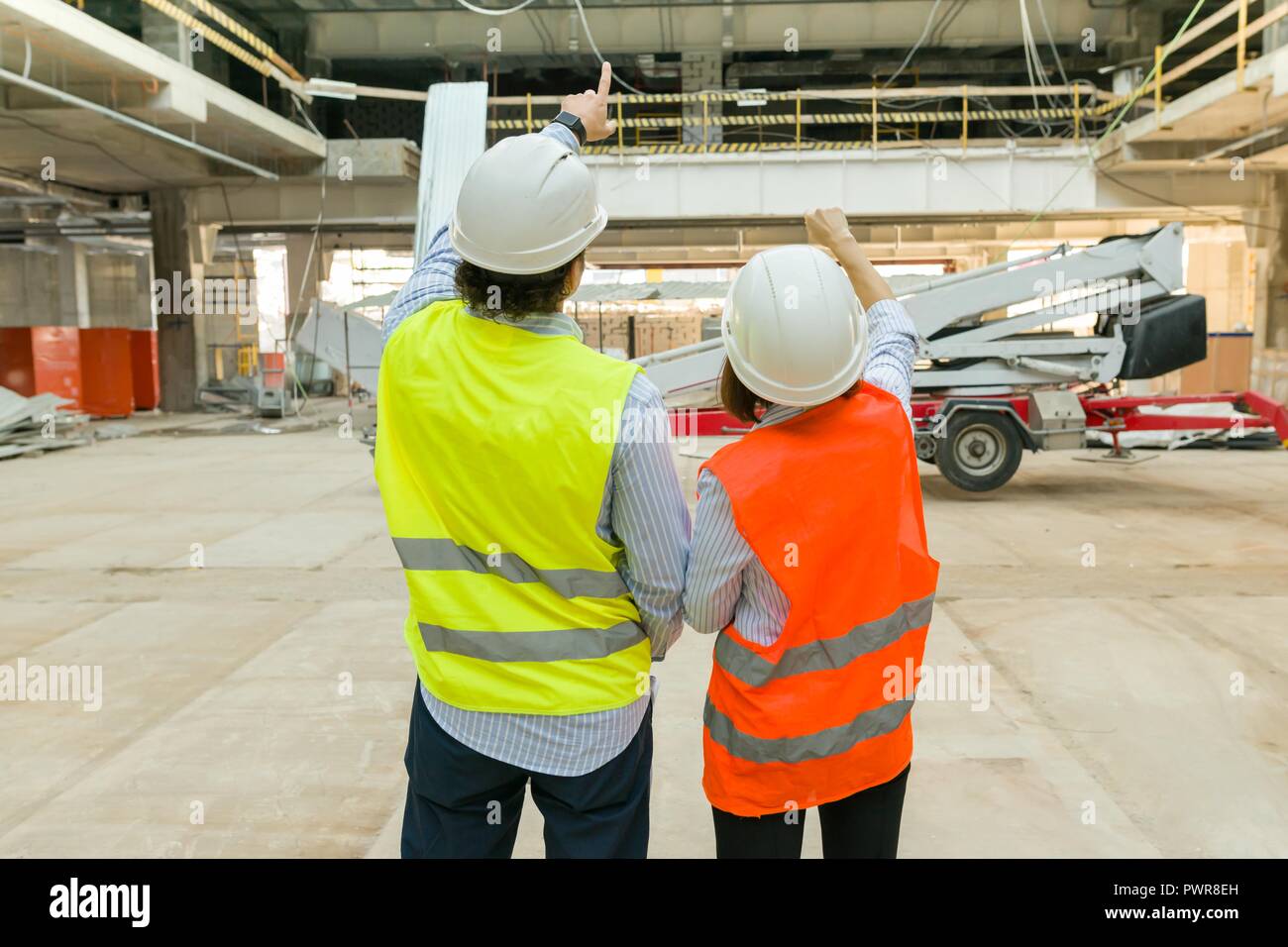 Woman and man builder at a construction site. Building, development ...