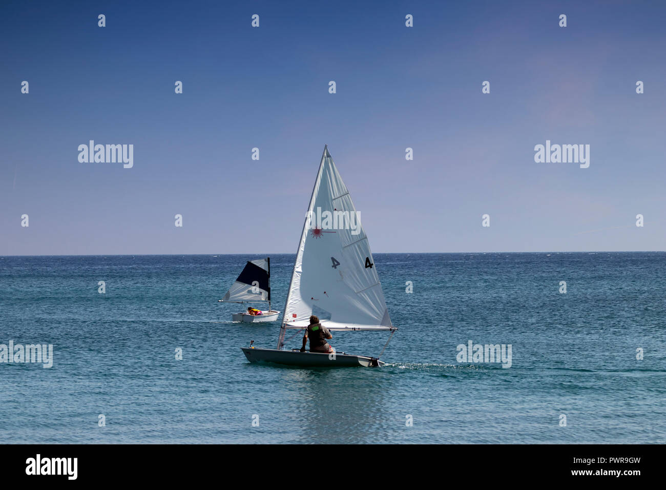Two small sailboats with one man crew sail the Aegean sea near the ...