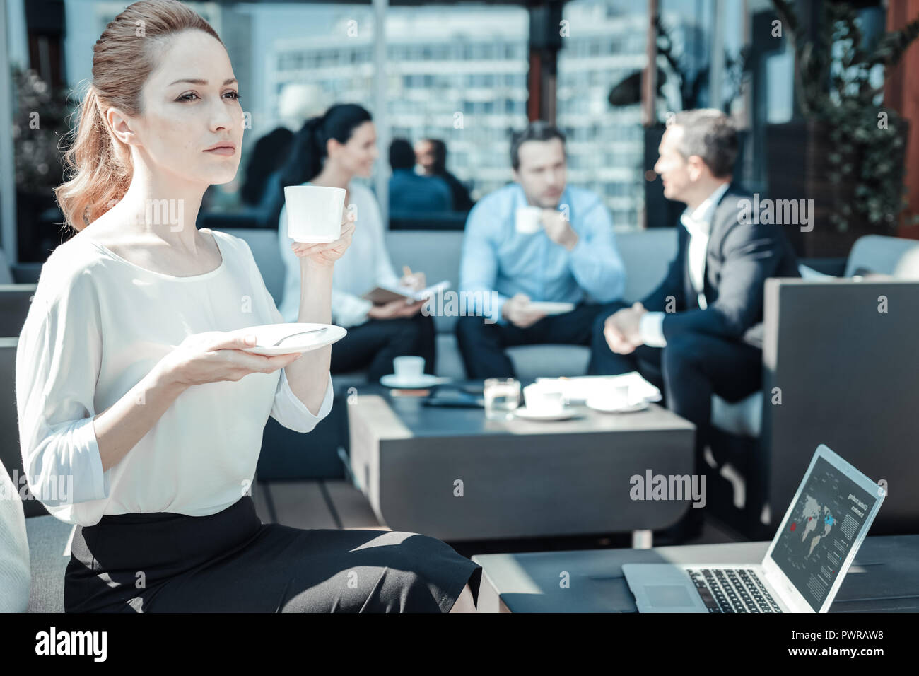 Frustrated blonde woman drinking coffee Stock Photo - Alamy