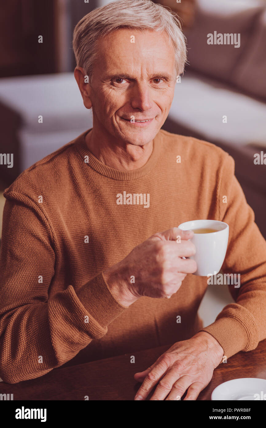 Delighted man having tea an relaxing Stock Photo - Alamy