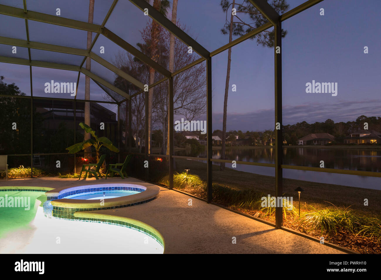 Nighttime view of luxury Florida home with screened in swimming pool ...