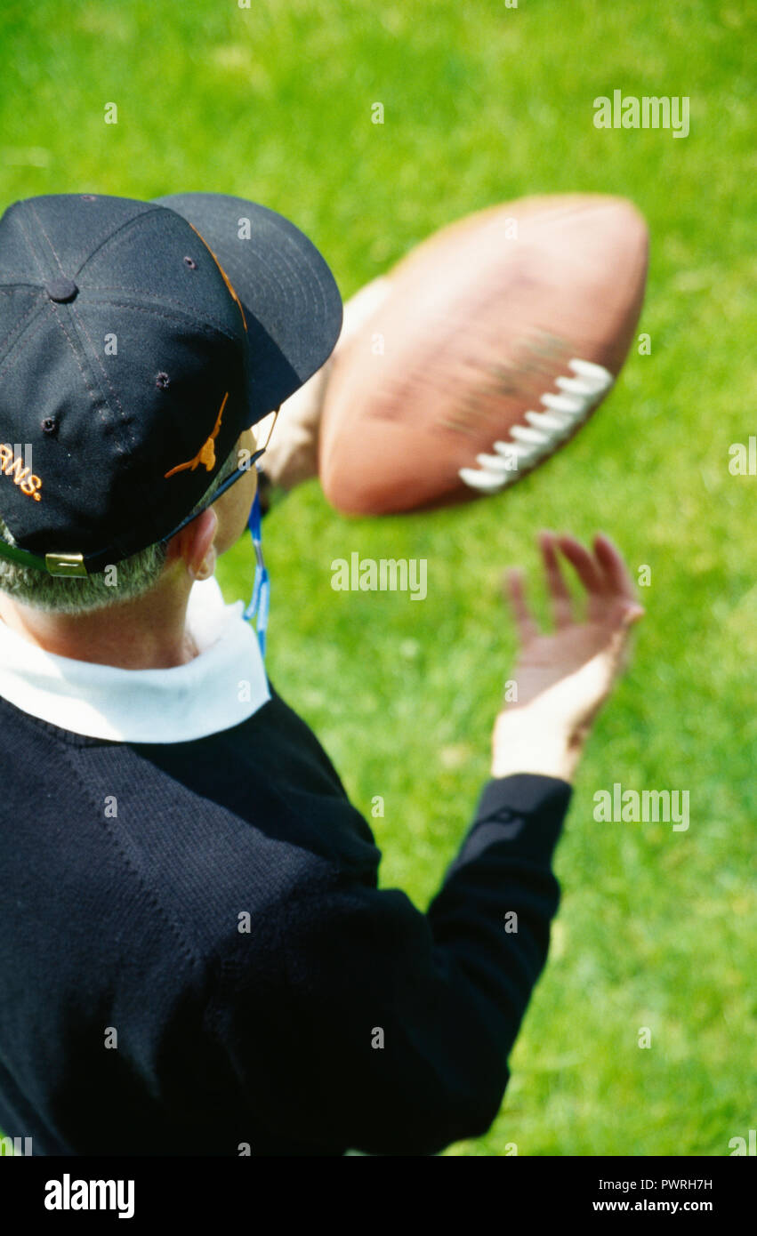 Football Coach with ball on sidelines, USA Stock Photo - Alamy