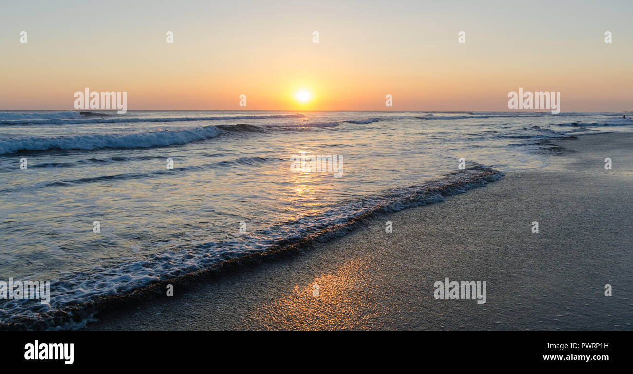 Sunset on a beach Stock Photo - Alamy