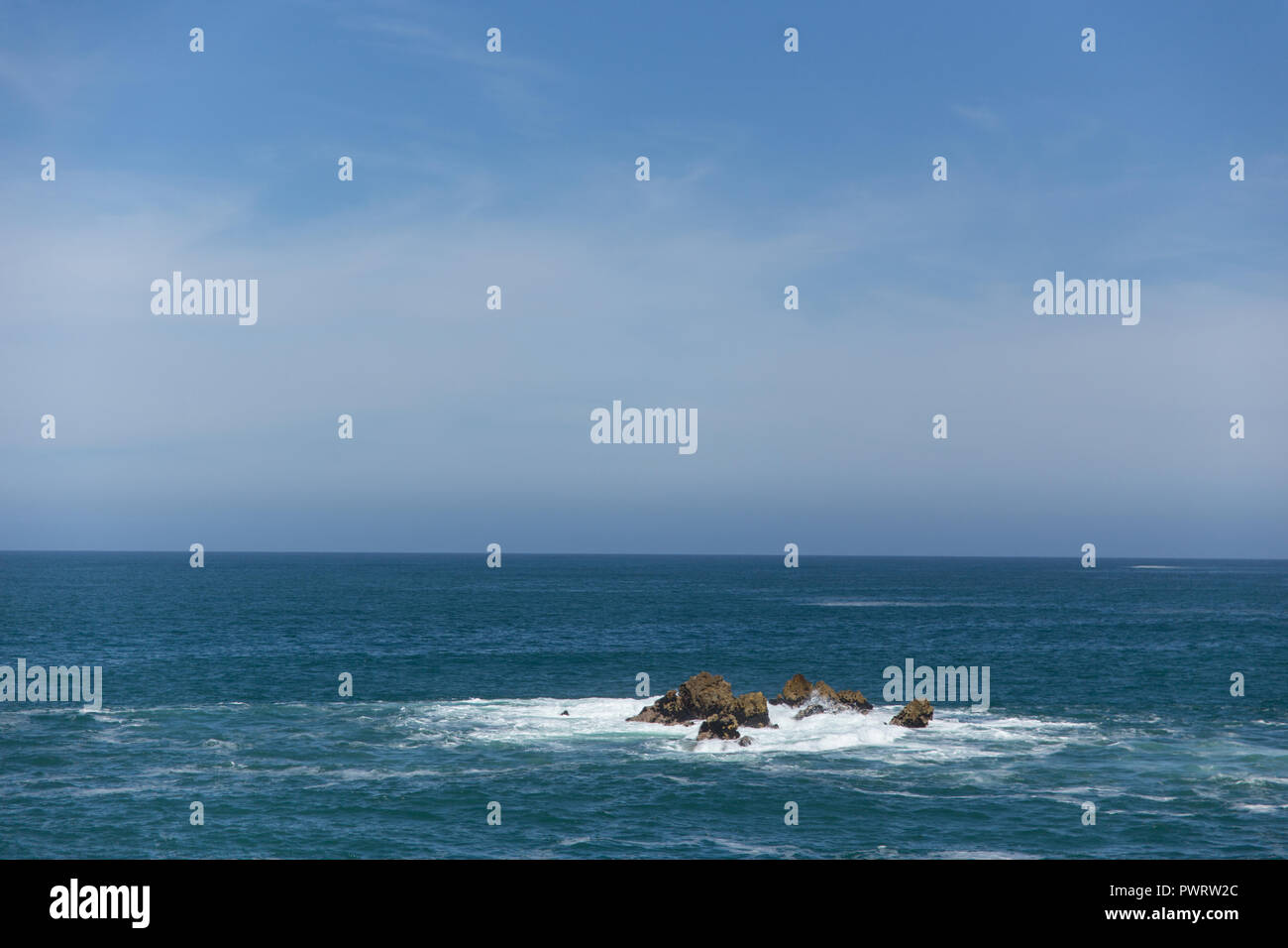 Rocks in the ocean water with foamy white sea Stock Photo - Alamy