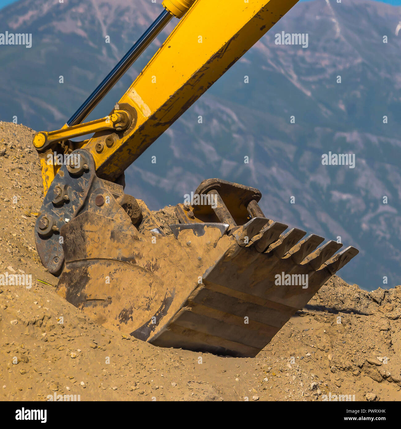 Arm of extractor scooping up dirt on a sunny day Stock Photo - Alamy