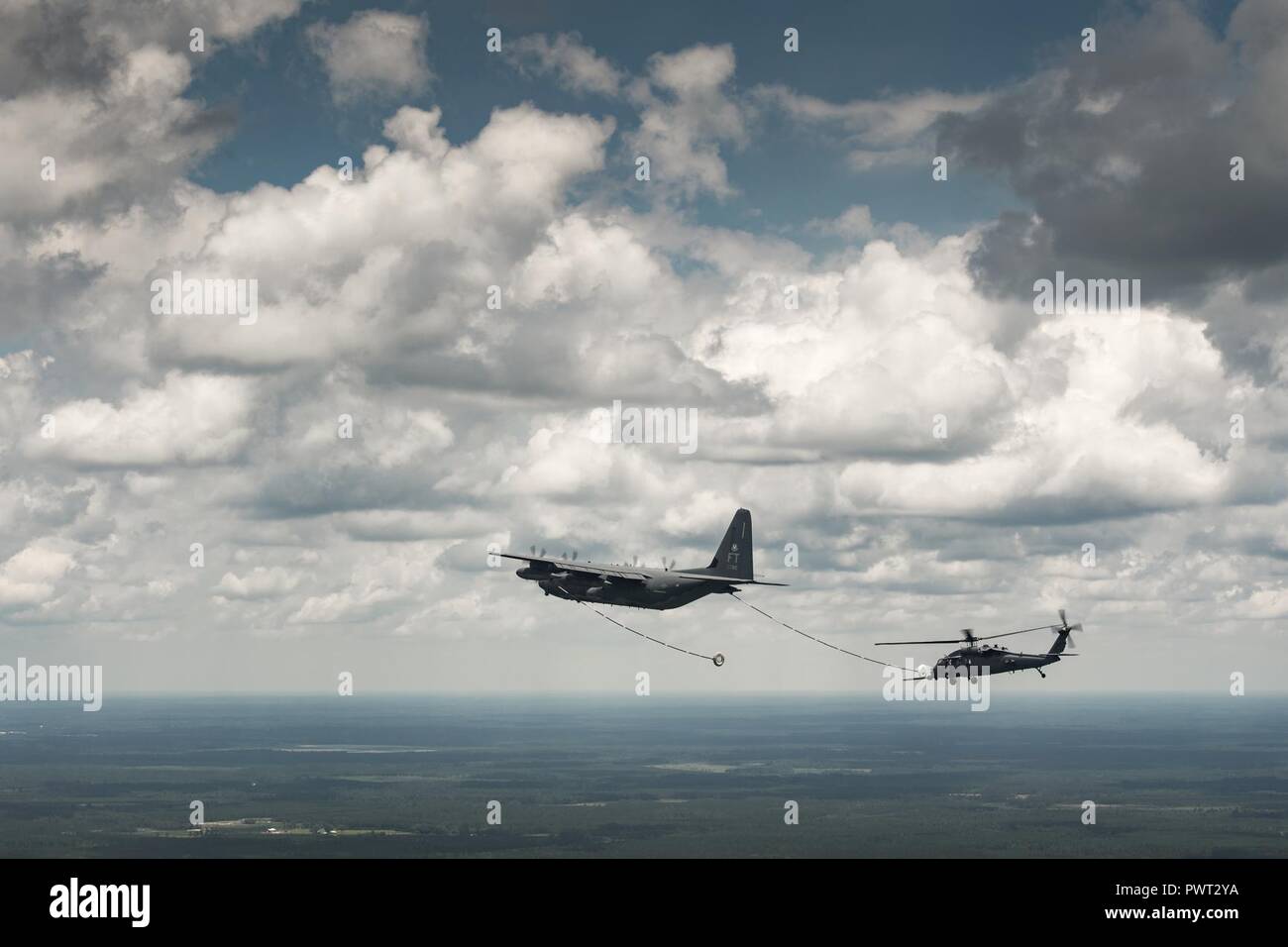 An HH-60G Pave Hawk from the 41st Rescue Squadron approaches an HC-130J ...