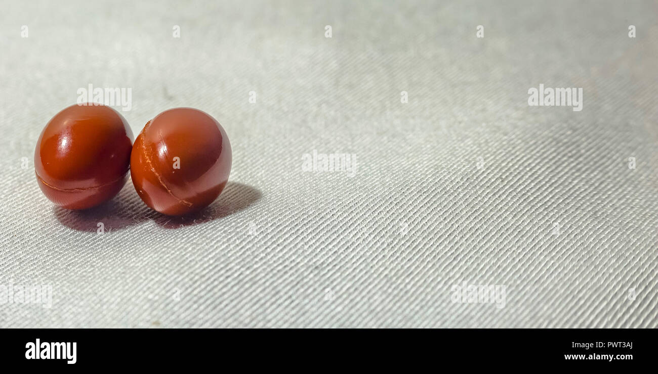Couple of pills on a white fabric texture surface Stock Photo - Alamy