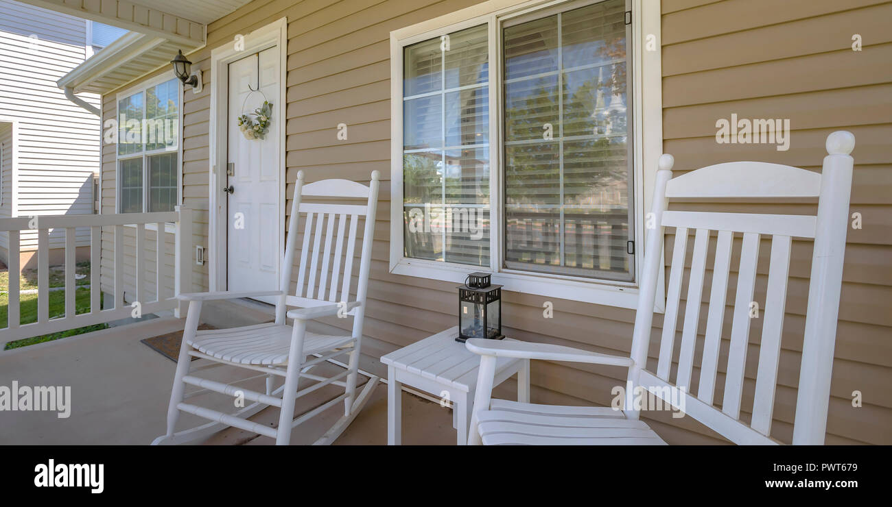 Home with rocking chairs and table on front porch Stock Photo - Alamy