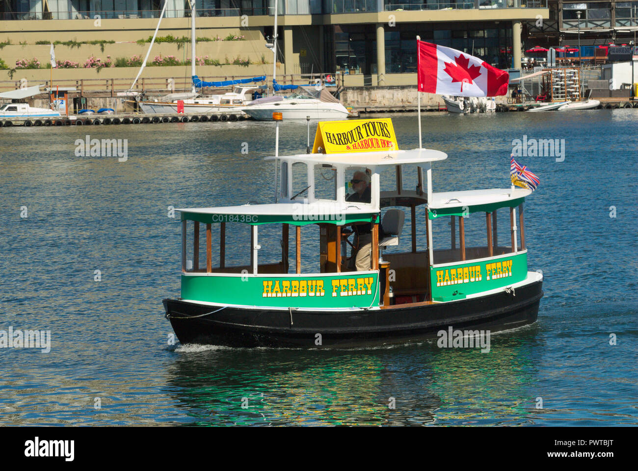 A small ferry plies the waters of the inner harbor in Victoria, British ...