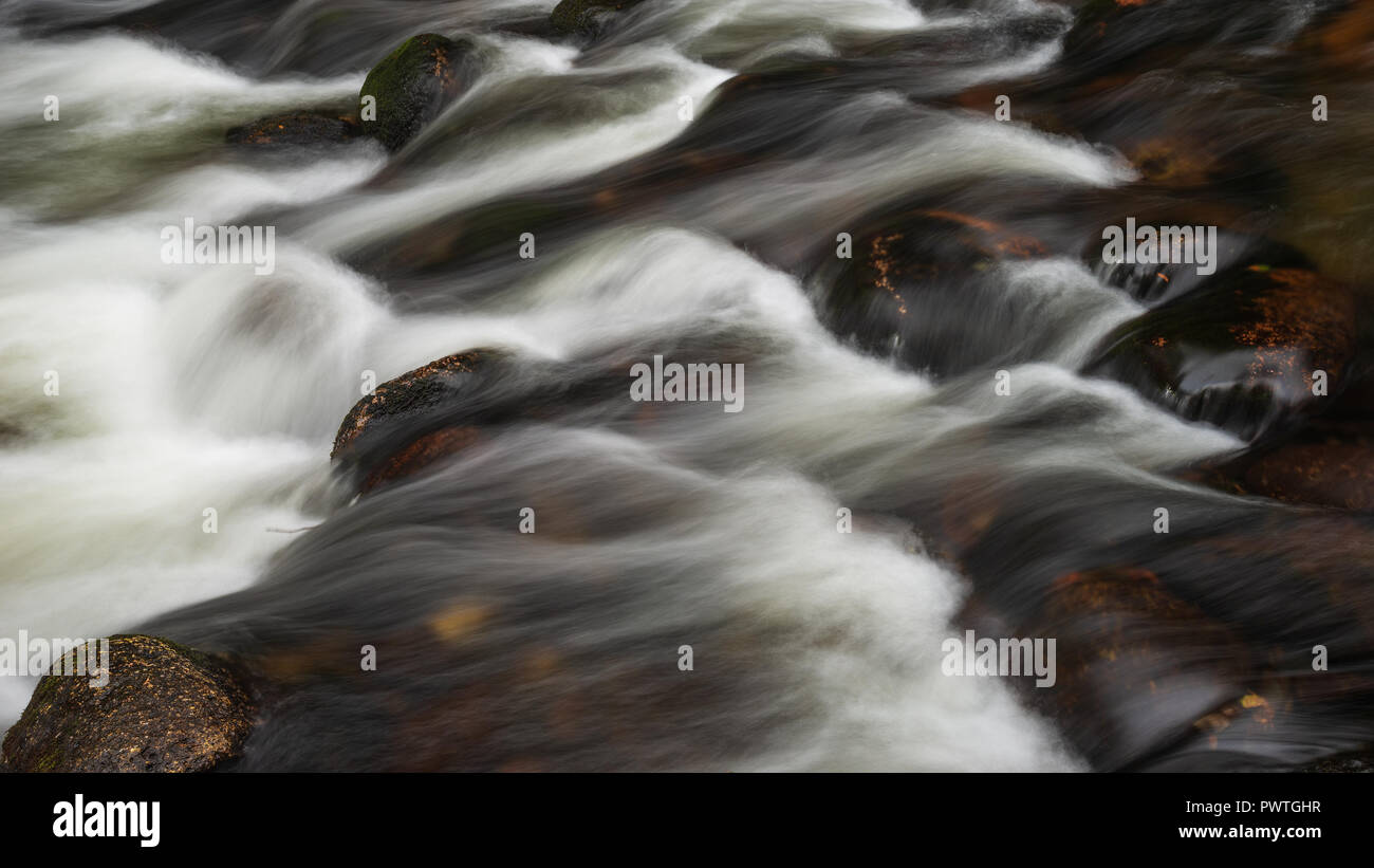 Detail landscape image of river flowing over rocks with long exposure ...