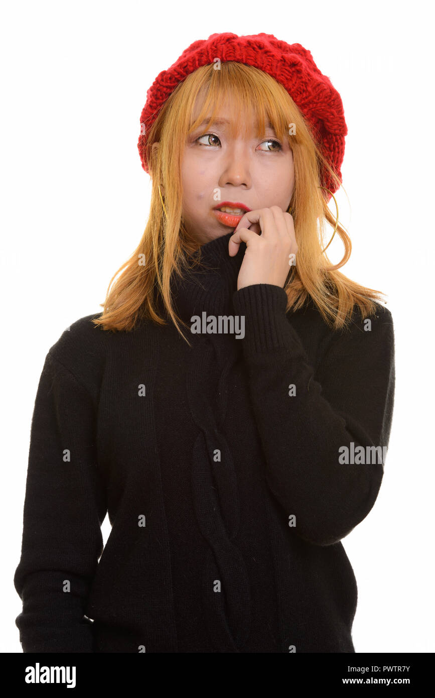 Young cute Asian woman thinking while holding sweater Stock Photo - Alamy