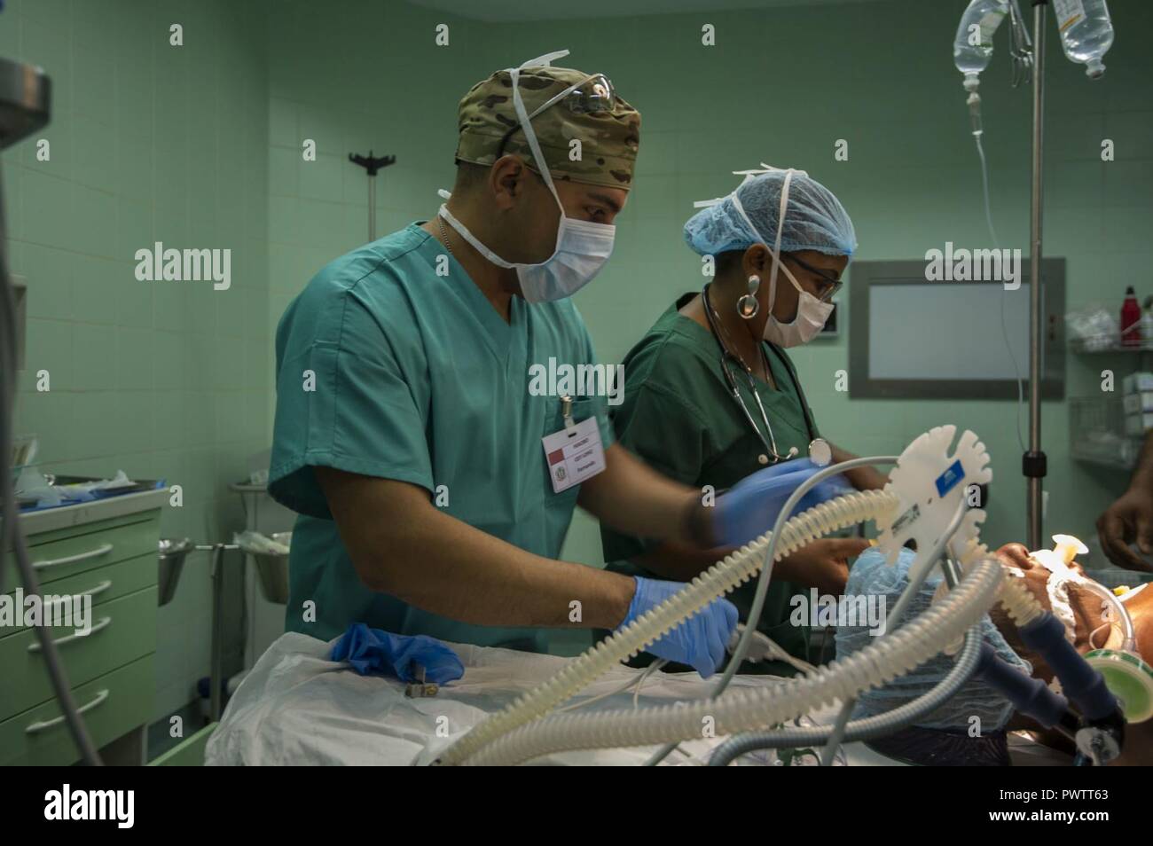 U.S. Army Maj. Fernando Lopez, a nurse anesthetist, checks on a patient ...