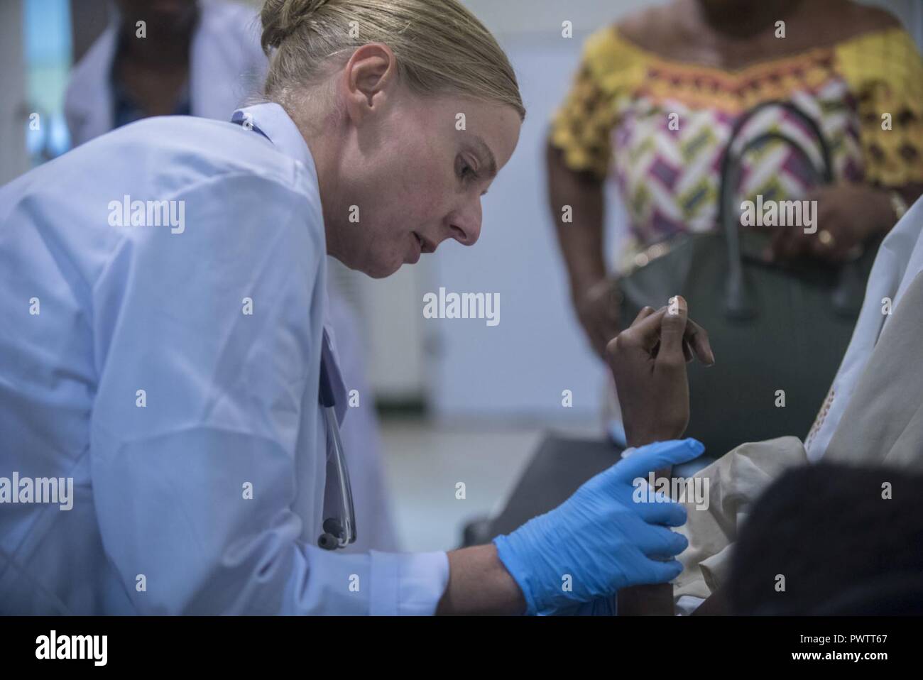 U.S. Army 1st Sgt. Donna Wilson, a practicing nurse specialist, removes ...