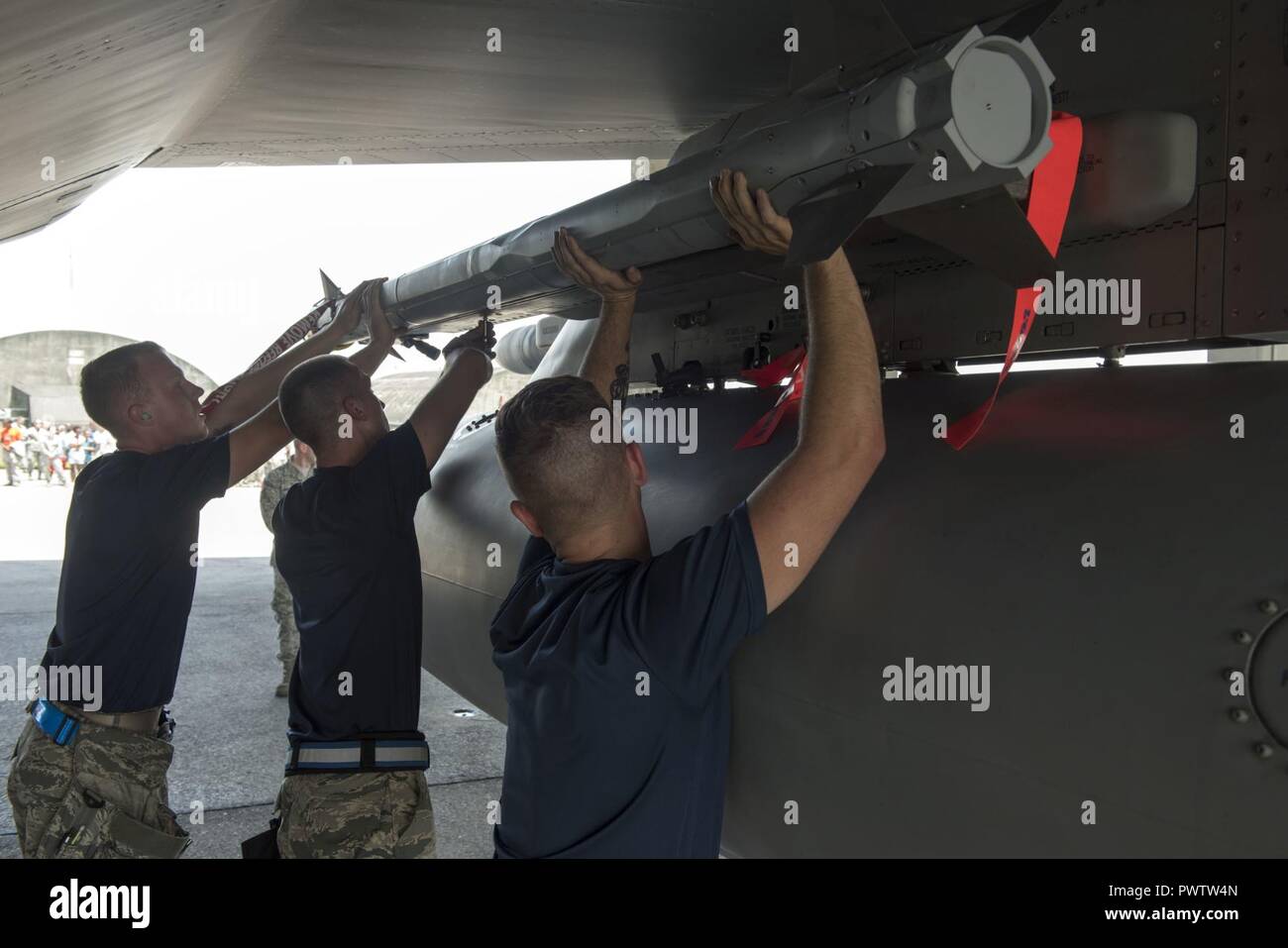 A weapons load team from the 44th Aircraft Maintenance Unit loads an ...
