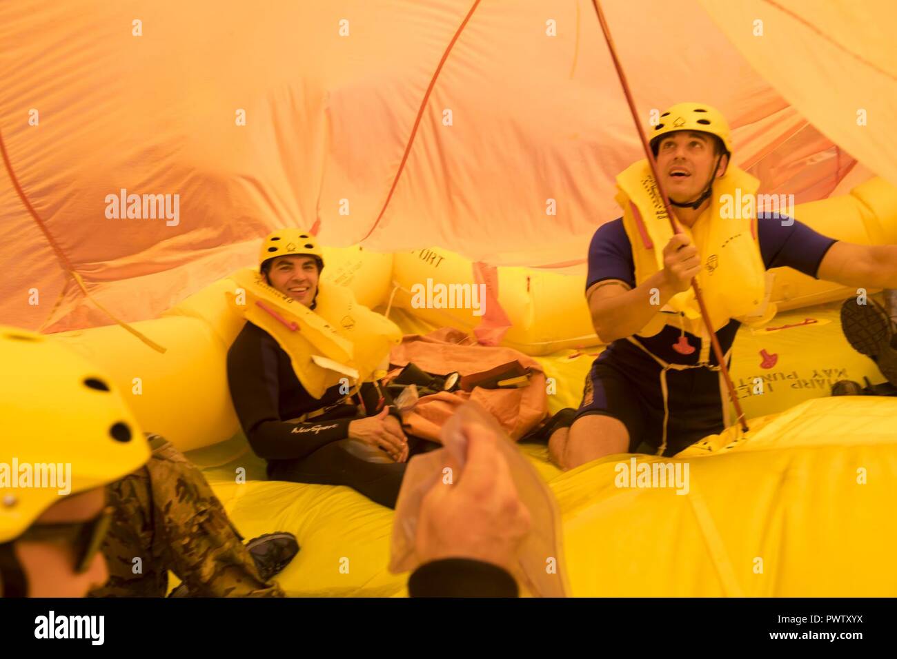 Water survival training students work to erect a tarp cover for their ...