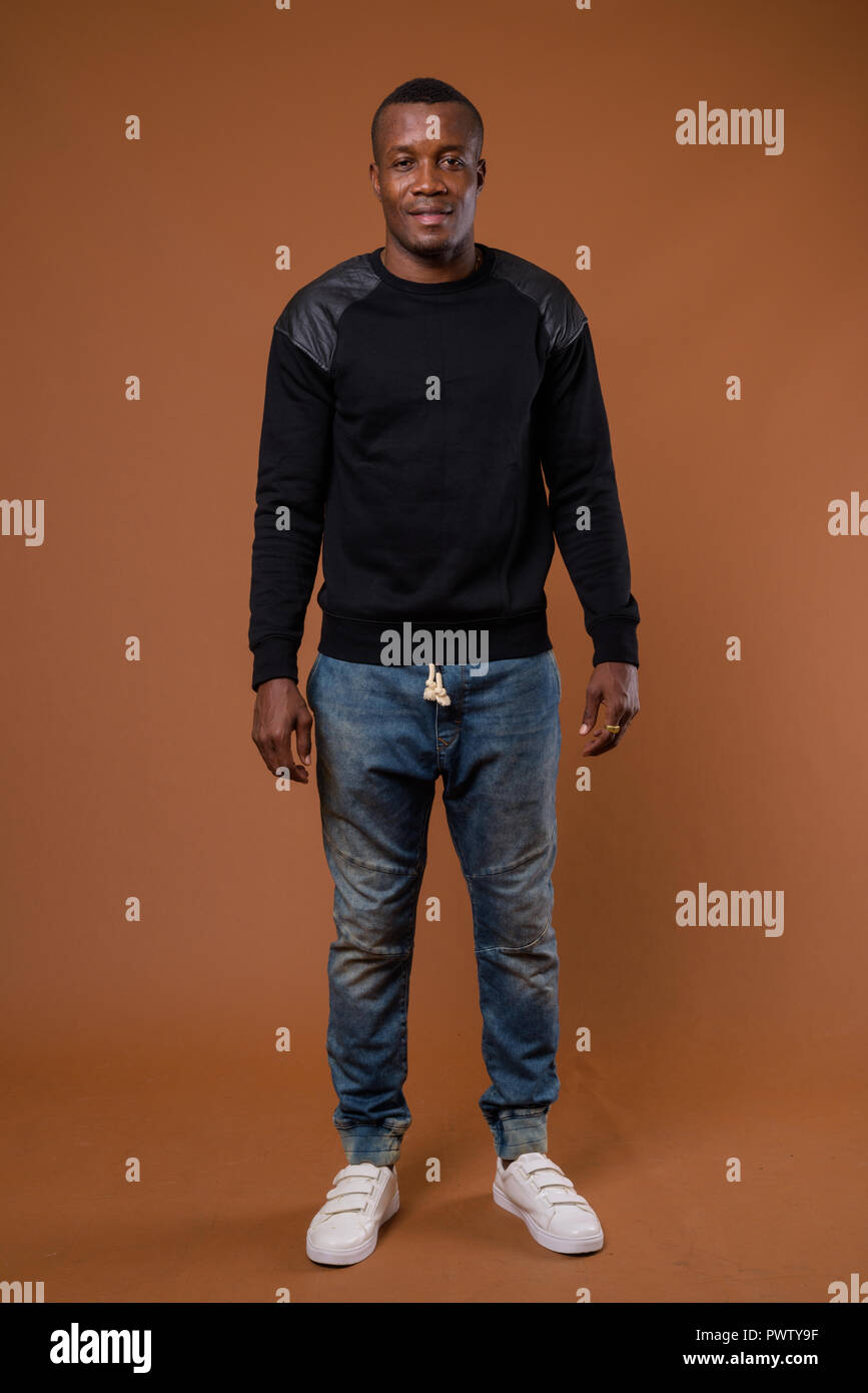 Studio shot of young African man against brown background Stock Photo ...