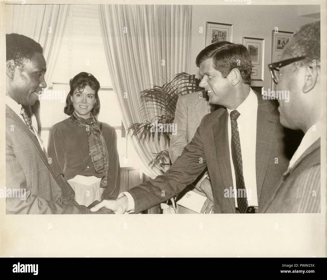 TWO MEN ARE GREETING EACH OTHER WITH ANOTHER MAN AND WOMAN NEXT TO THEM ...