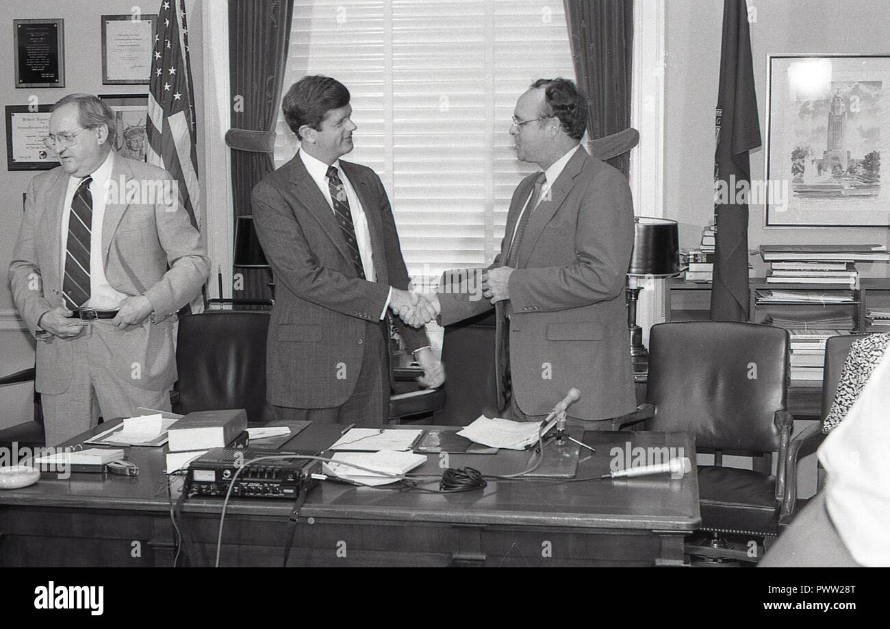 TWO MEN GREETING EACH OTHER WITH ANOTHER MAN NEXT TO THEM Stock Photo ...