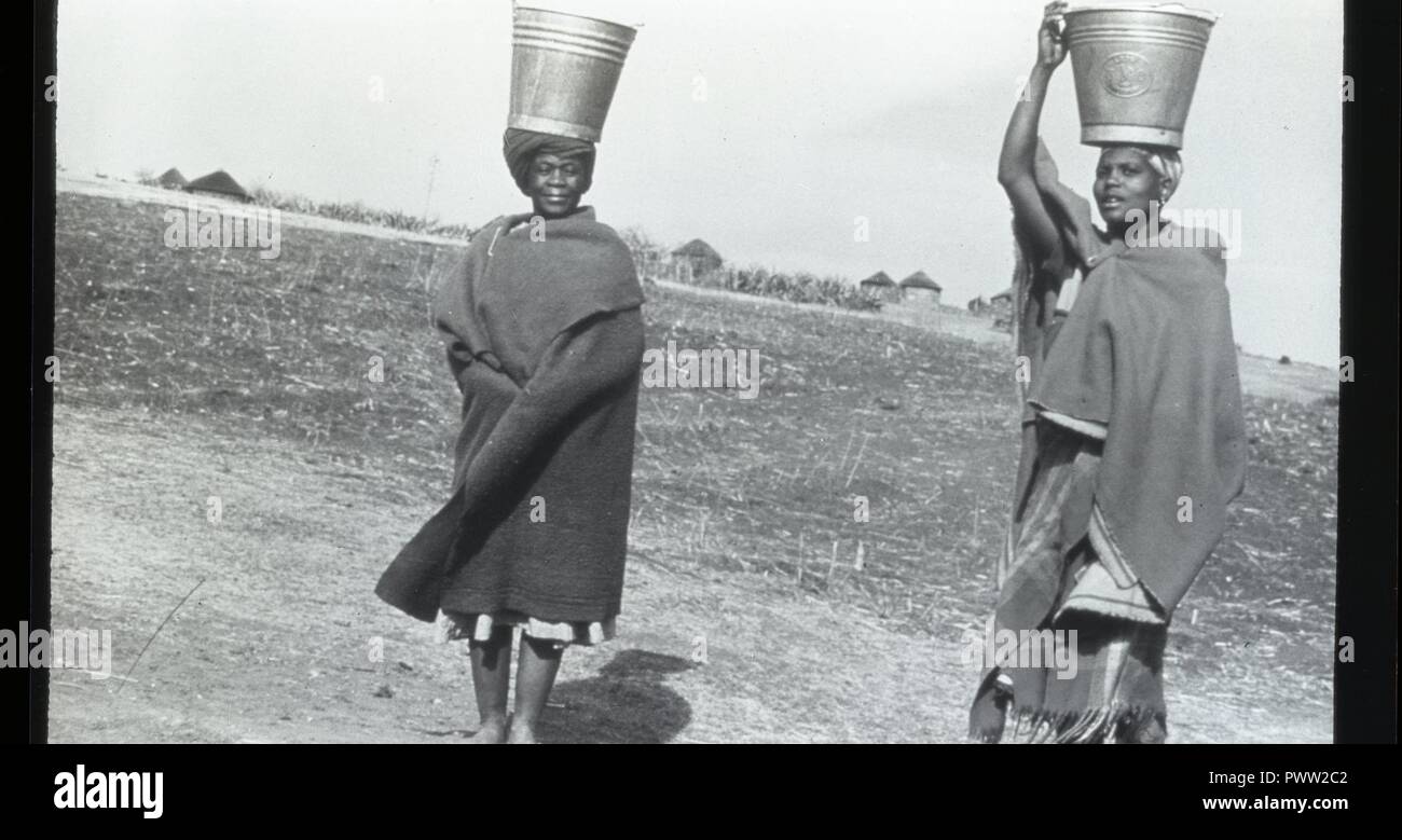 TWO WOMEN WALKING ON THE ROAD WITH A BUCKET ON THERE HEADS Stock Photo ...