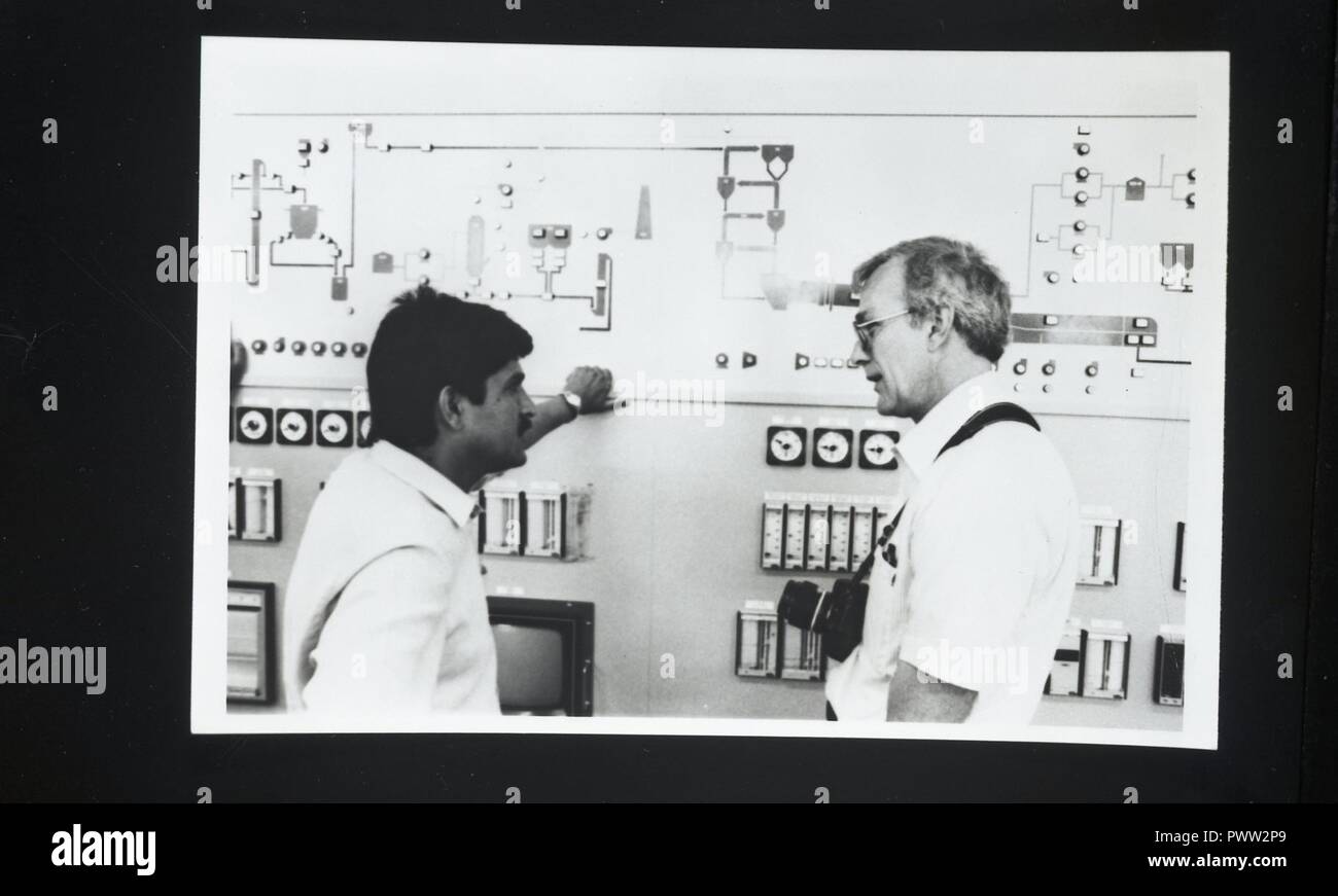 TWO MEN ARE HAVING A CONVERSATION IN FRONT OF A MACHINE Stock Photo - Alamy