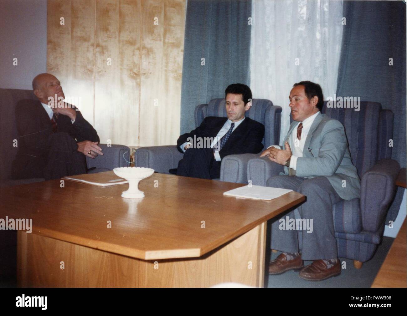 THREE MEN ARE SITTING DOWN HAVING A CONVERSATION Stock Photo - Alamy