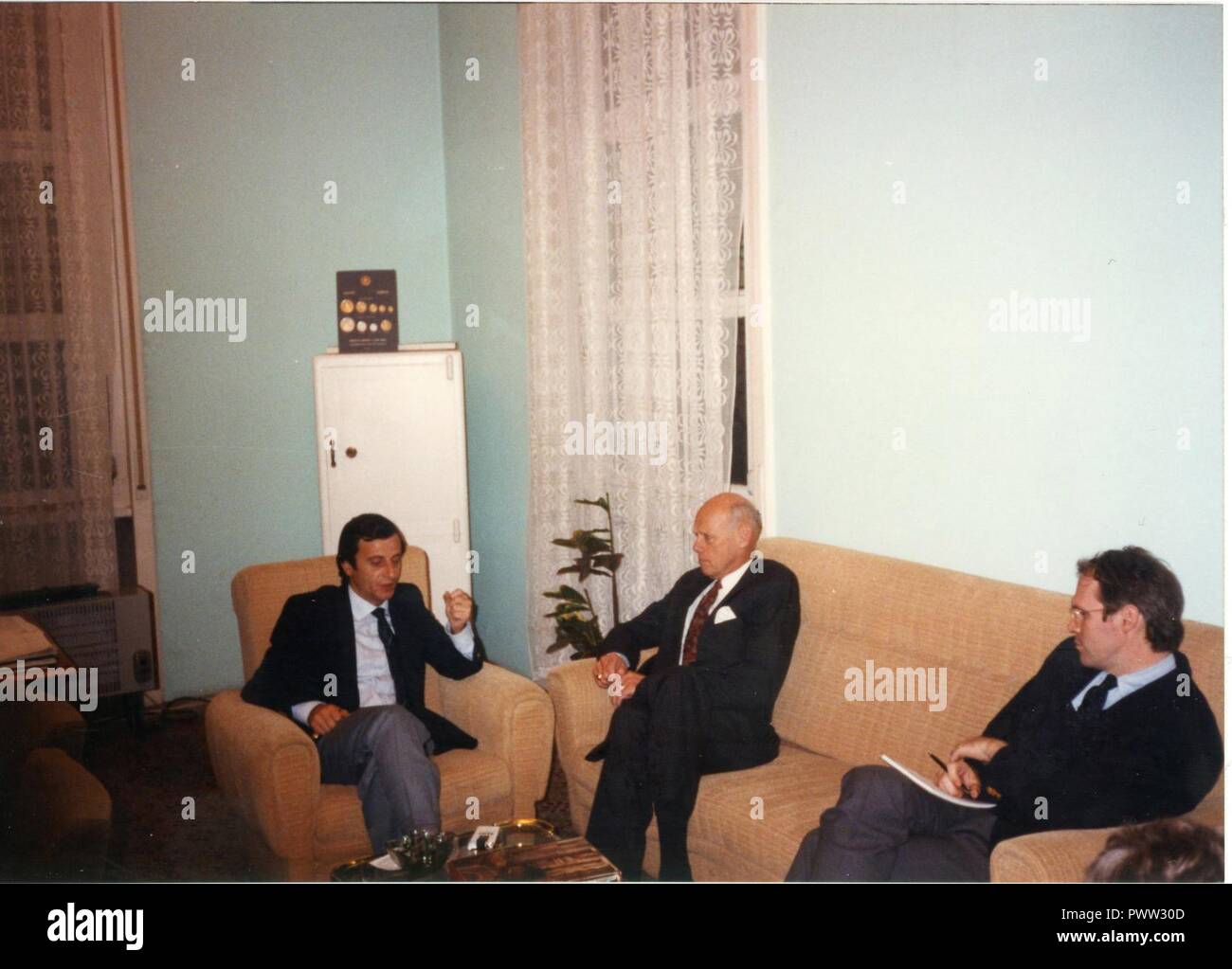 THREE MEN ARE SITTING DOWN HAVING A CONVERSATION Stock Photo - Alamy